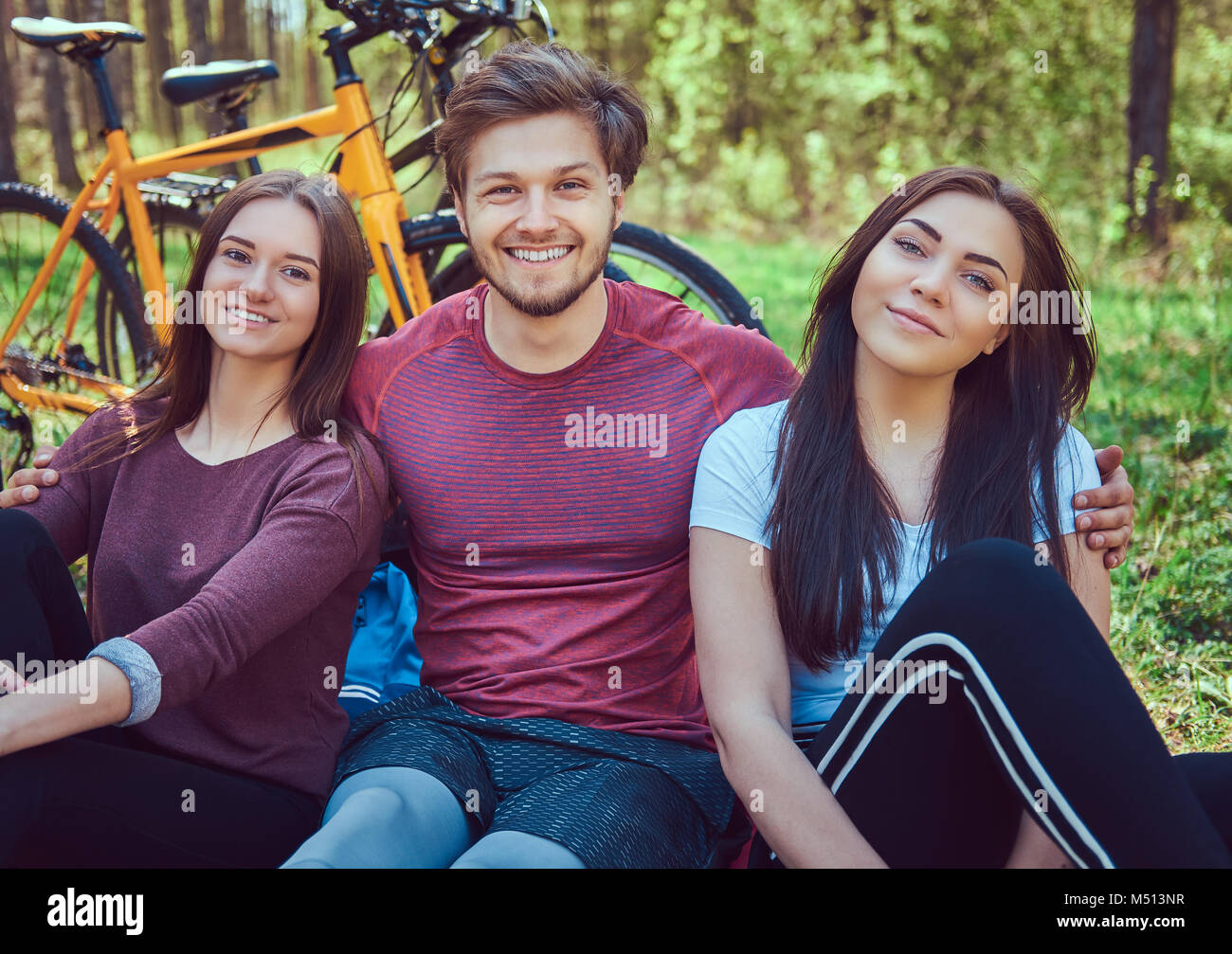 Group of young friends hiking through the forest with bikes on a Stock ...