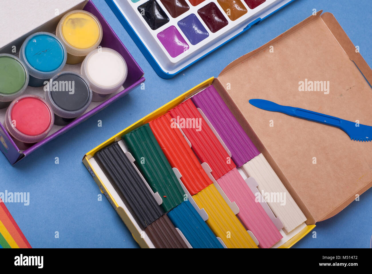 Set for a first grader, clay, paint, ruler on blue background, school ...