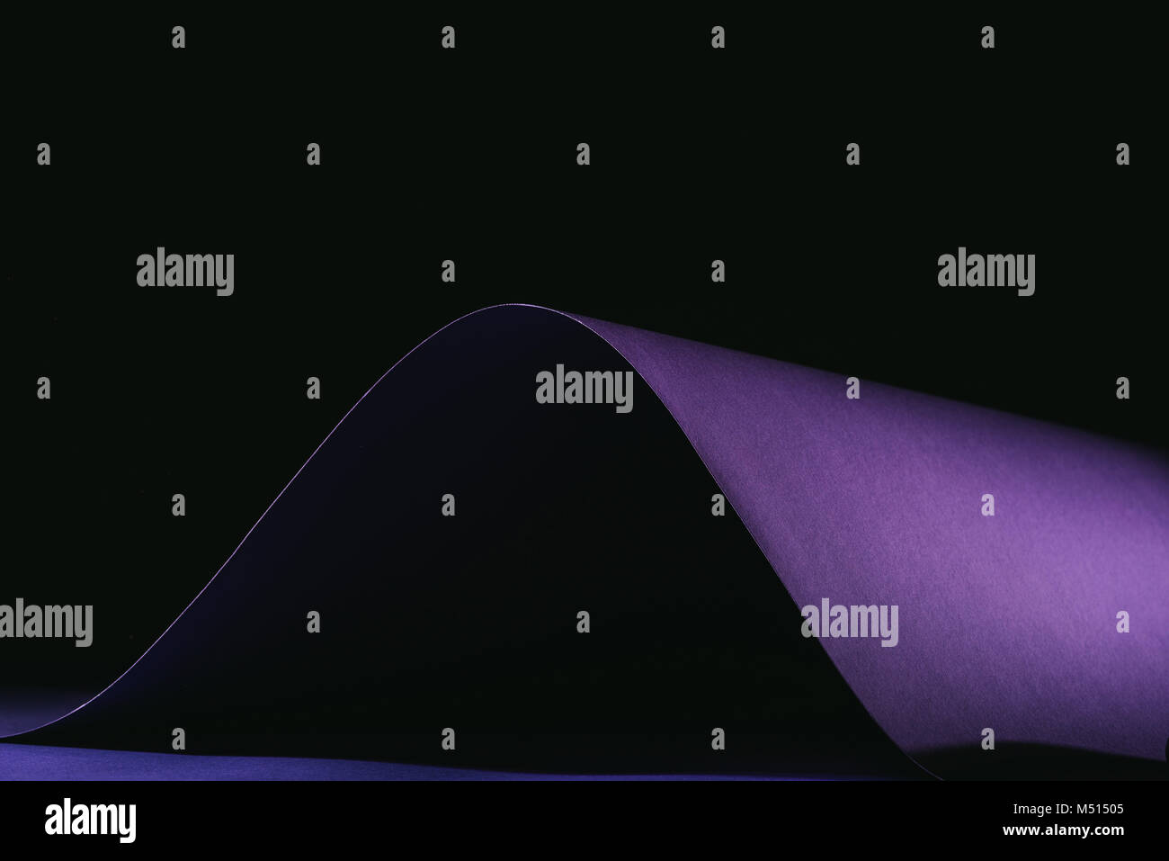warping simple purple paper on black Stock Photo - Alamy