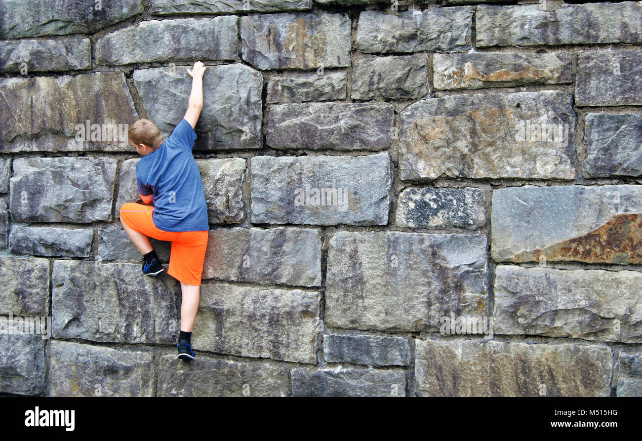 Boy climbing a Rock Wall Stock Photo - Alamy
