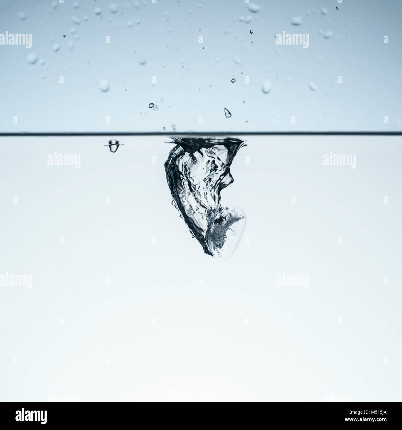 ice cube in water with splash, isolated on white Stock Photo - Alamy