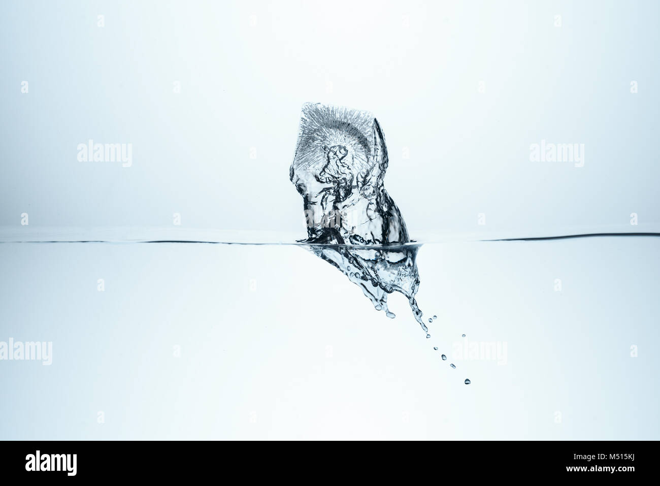 ice cube splashing in water, isolated on white Stock Photo - Alamy