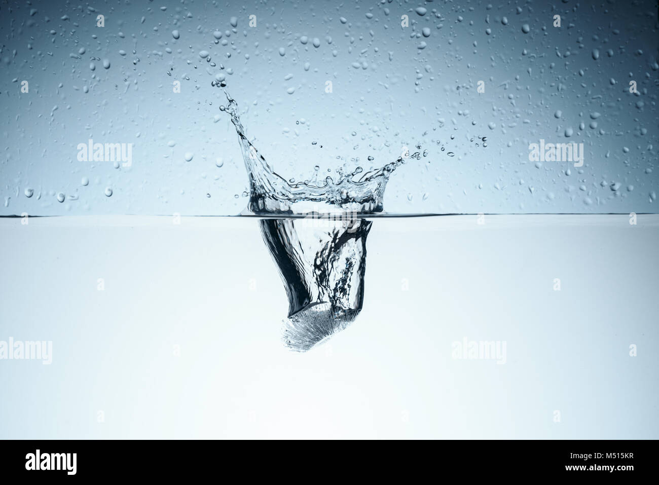 ice cube in water with splash, isolated on white Stock Photo - Alamy