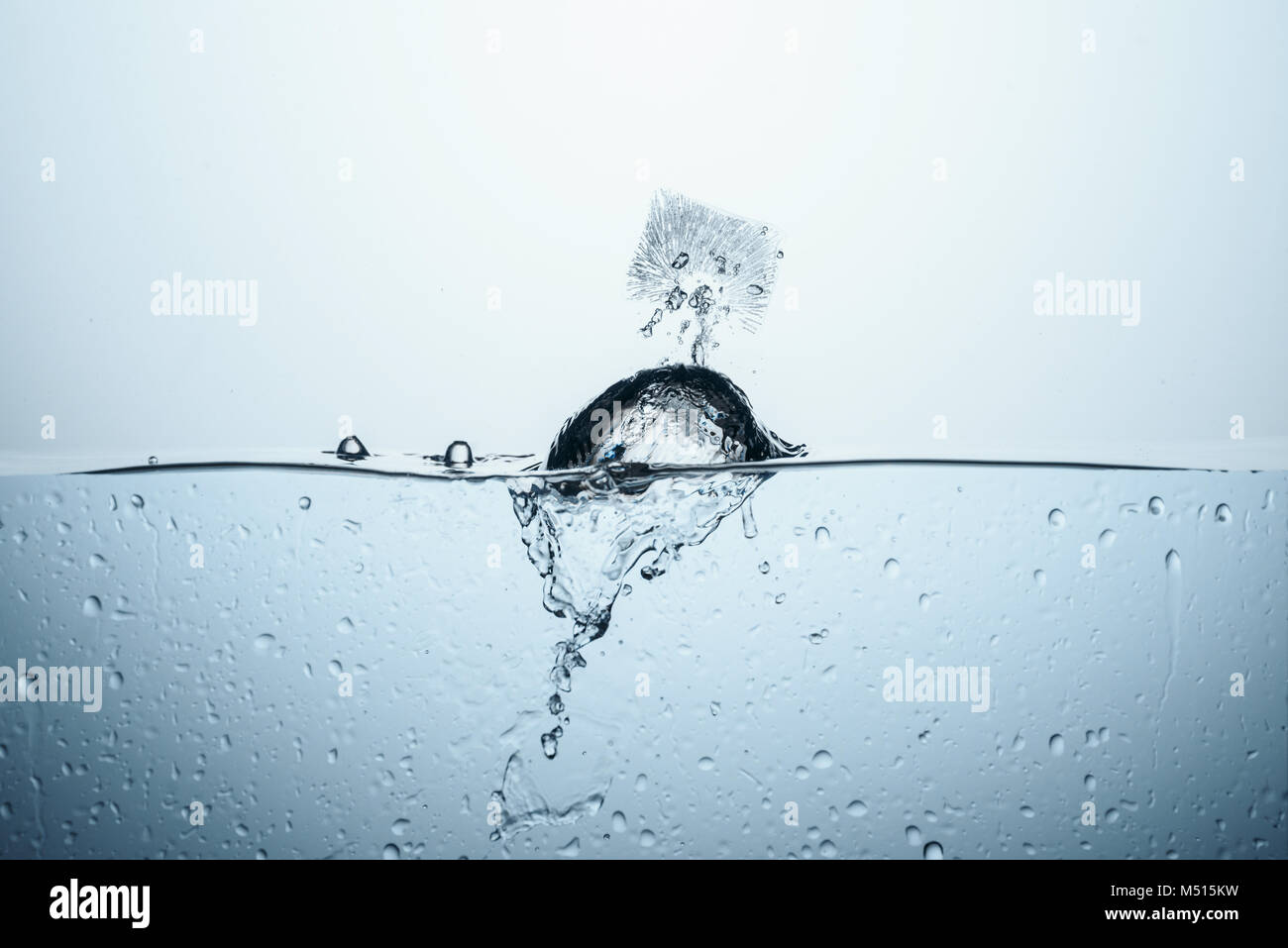 ice cube in water with splash, isolated on white Stock Photo - Alamy