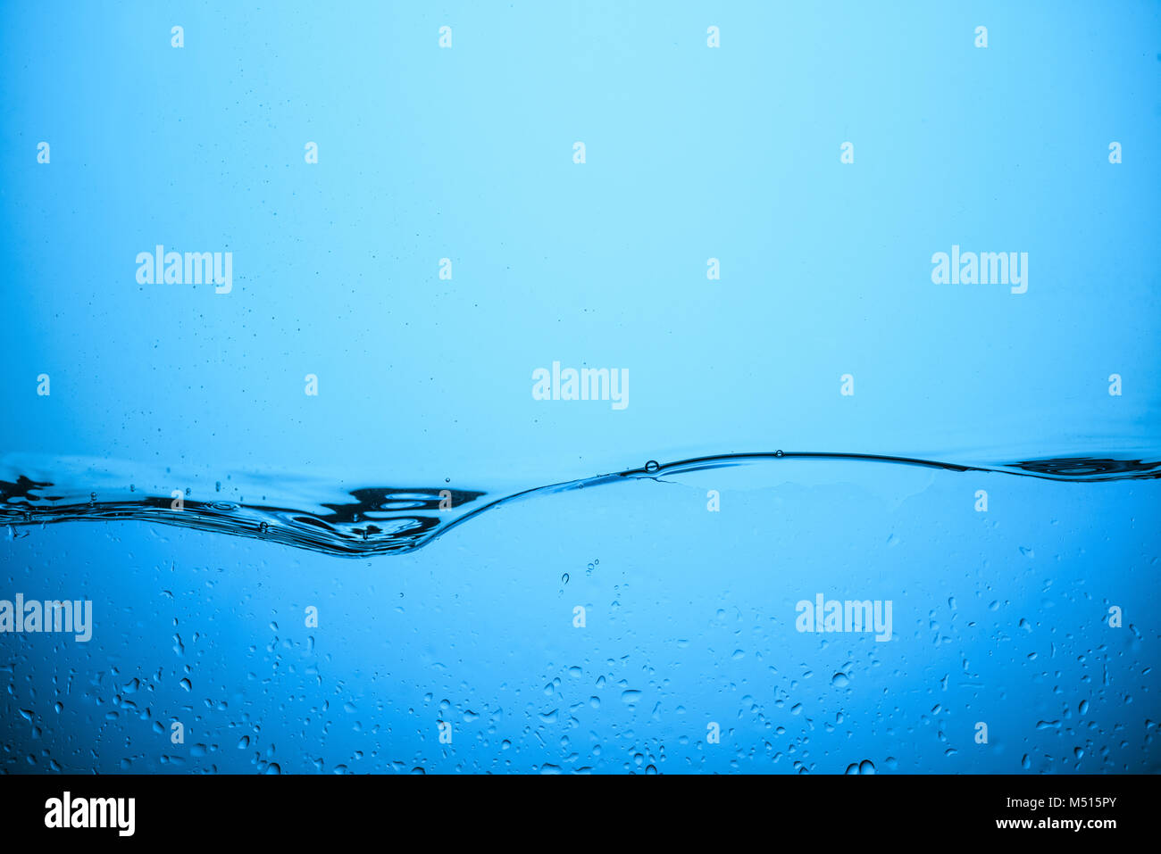 flowing water background with drops, isolated on blue Stock Photo - Alamy