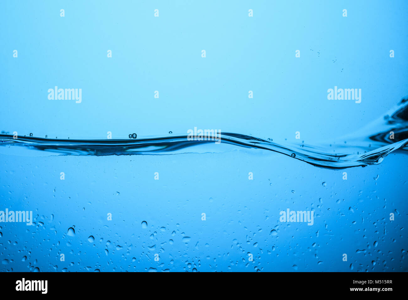 flowing pure water texture with drops, isolated on blue Stock Photo - Alamy