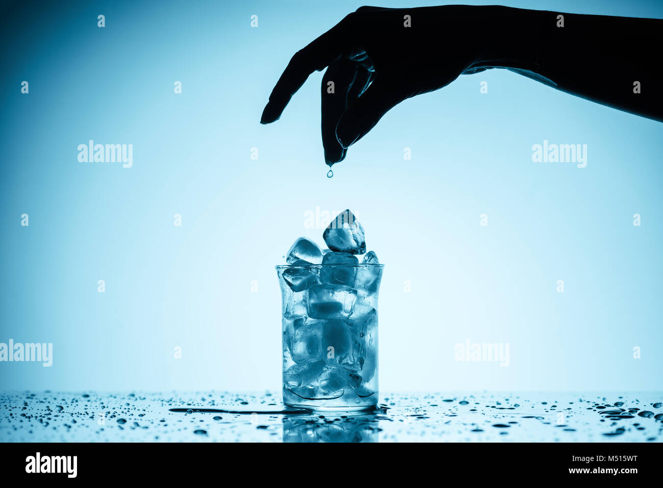 cropped view of person throwing ice cubes into glass Stock Photo - Alamy