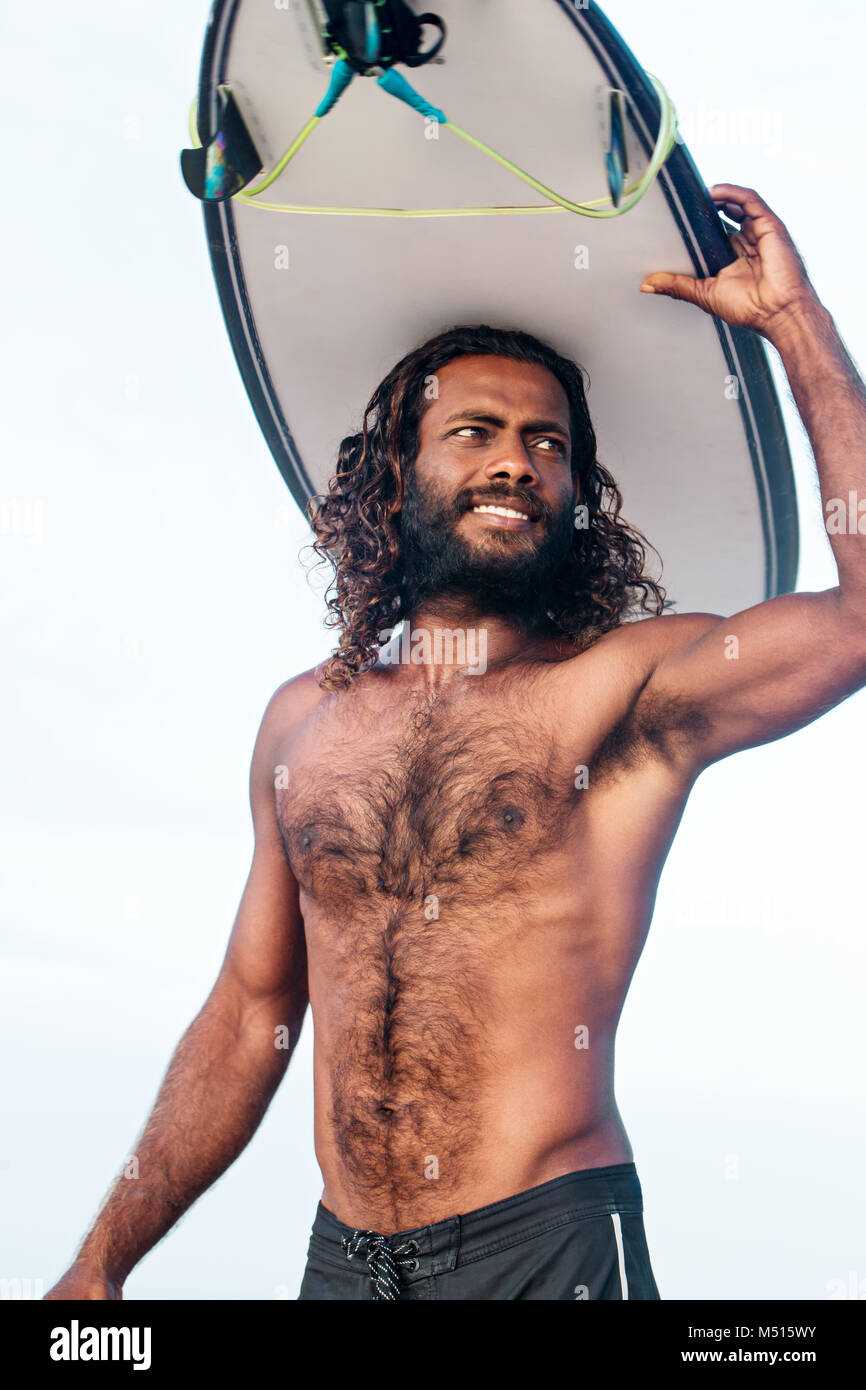 Surfer with surfboard on his head Stock Photo - Alamy