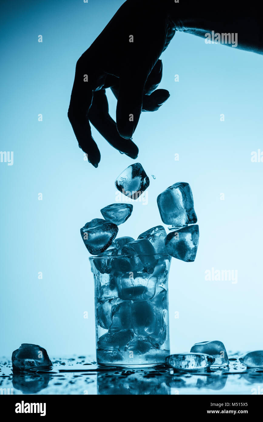 partial view of person throwing ice cubes into glass Stock Photo - Alamy