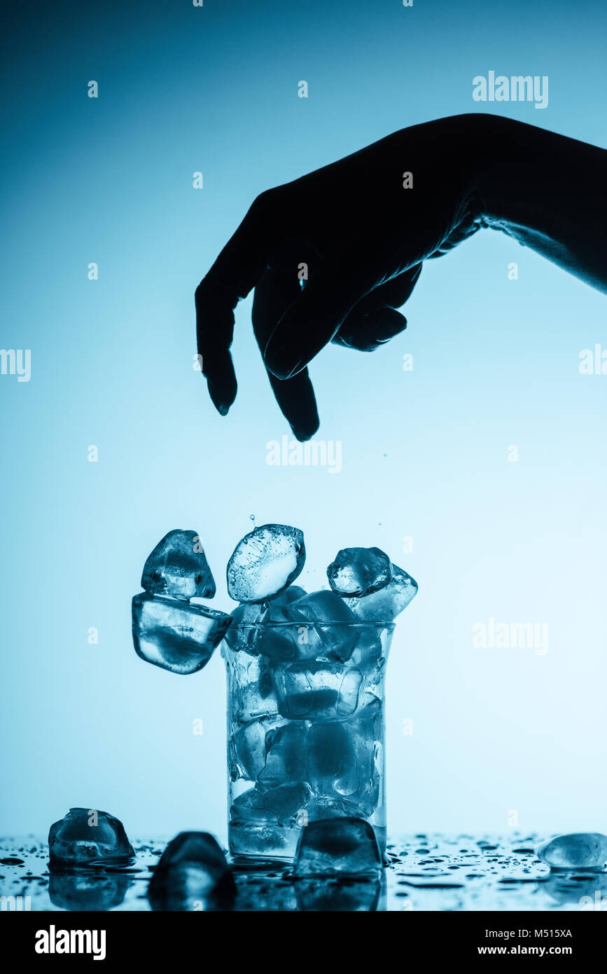 cropped view of person throwing ice cubes into glass Stock Photo - Alamy
