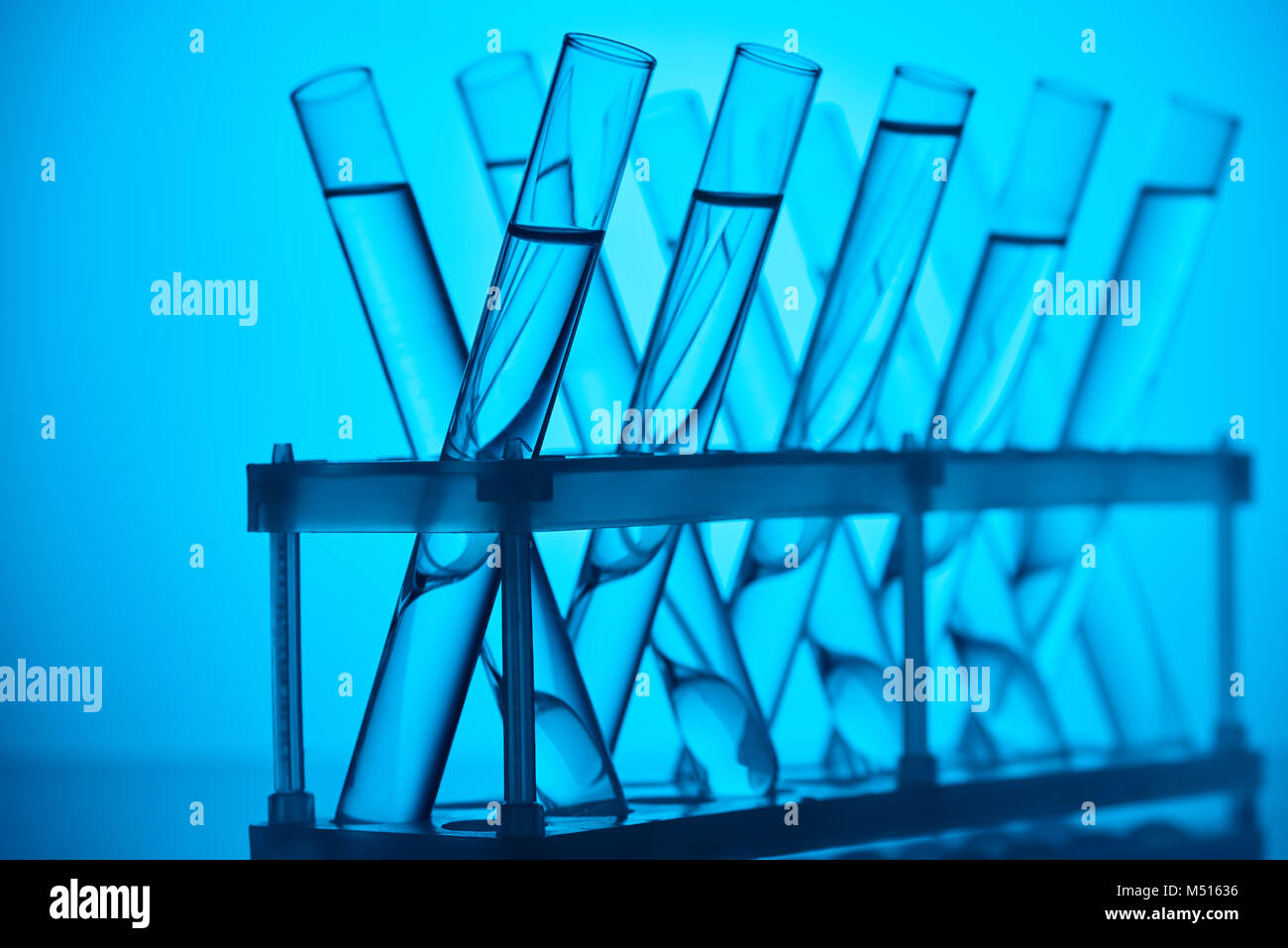 glass tubes with liquid on stand in laboratory on blue Stock Photo - Alamy