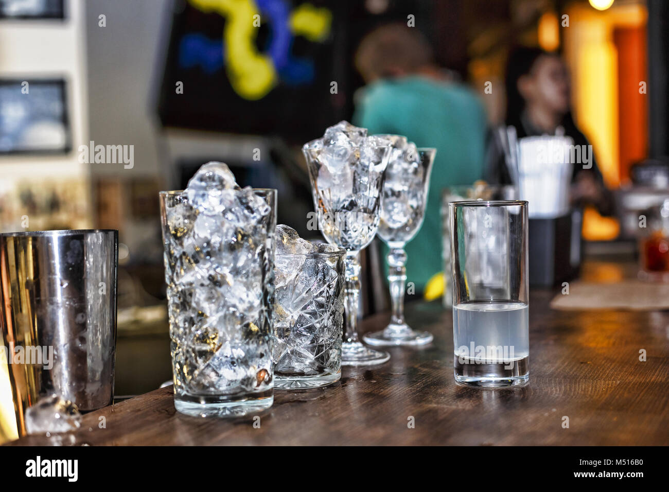 Ice in cocktail glasses on the bar. Preparation of cocktail Stock Photo ...