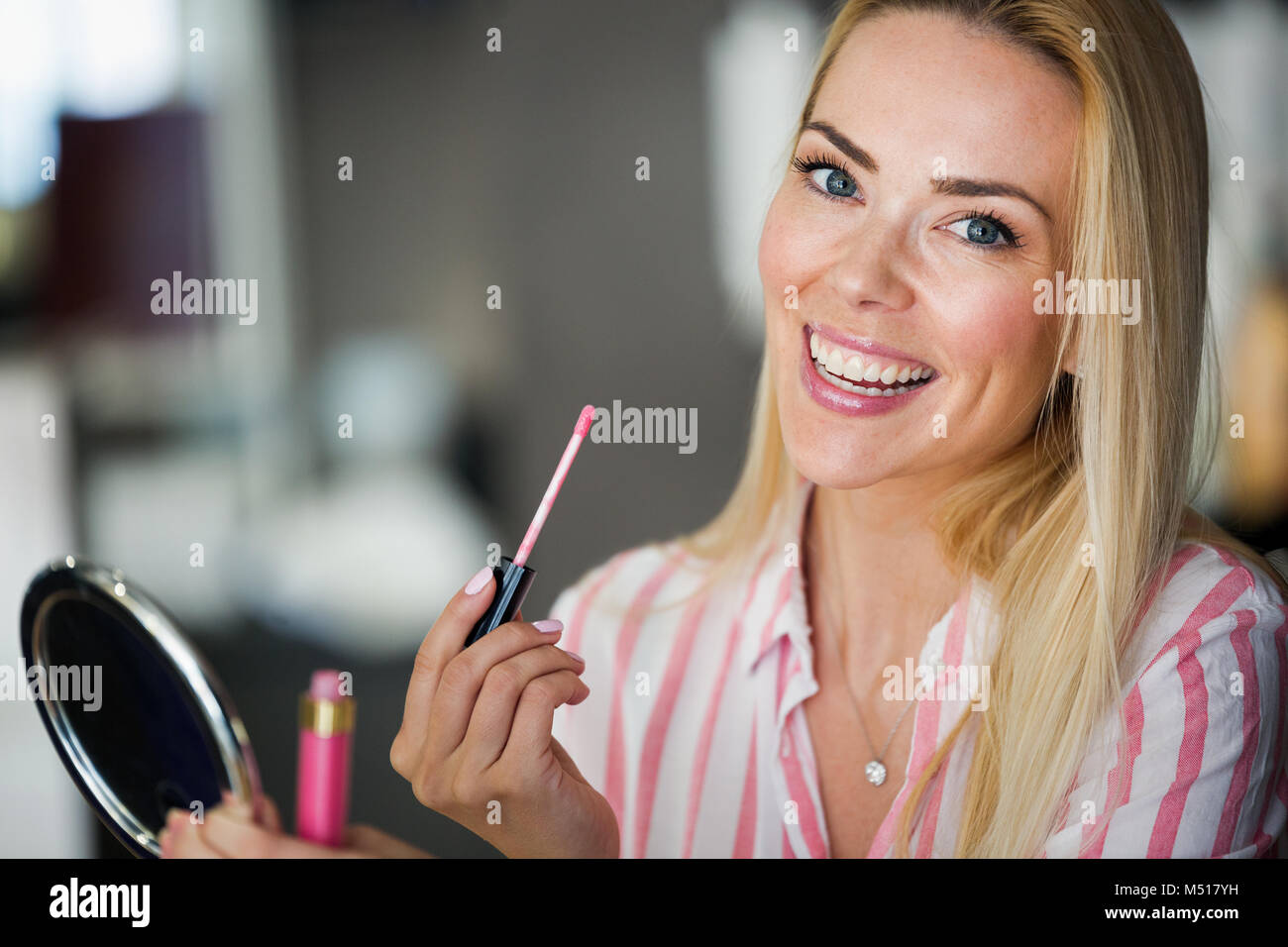 Young woman making make-up near mirror Stock Photo - Alamy