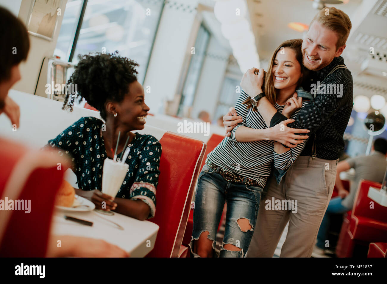 Group of young multiracial friends enjoying in the diner Stock Photo ...