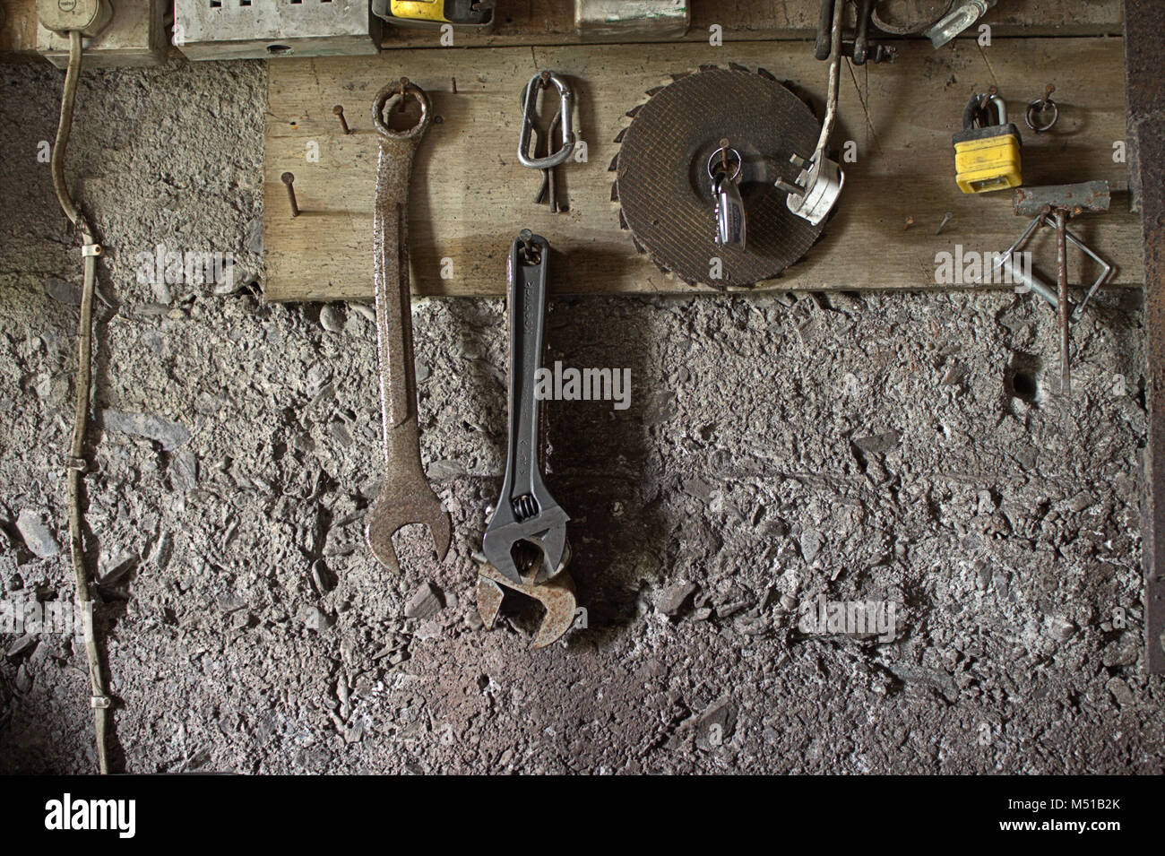 Old tools hanging on nails in a workshop Stock Photo - Alamy