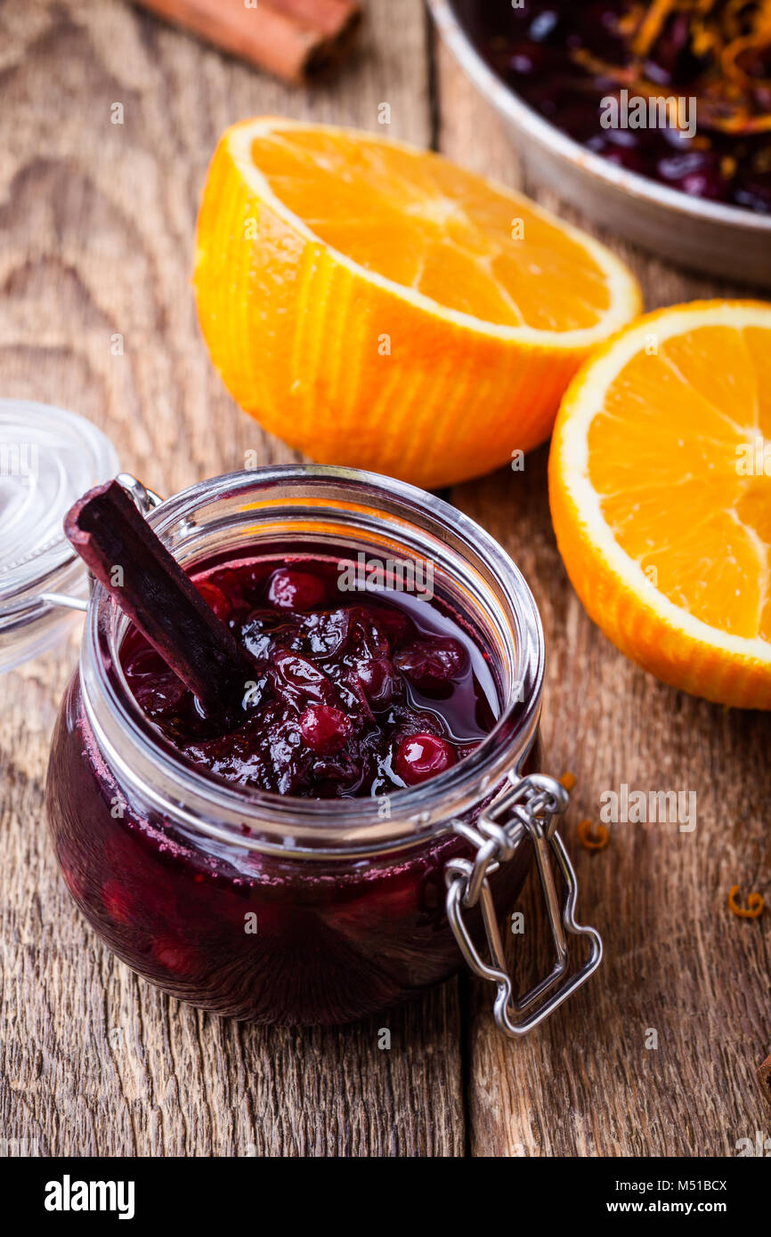 Cranberry sauce in glass jar with ingrediens on wooden table Stock ...