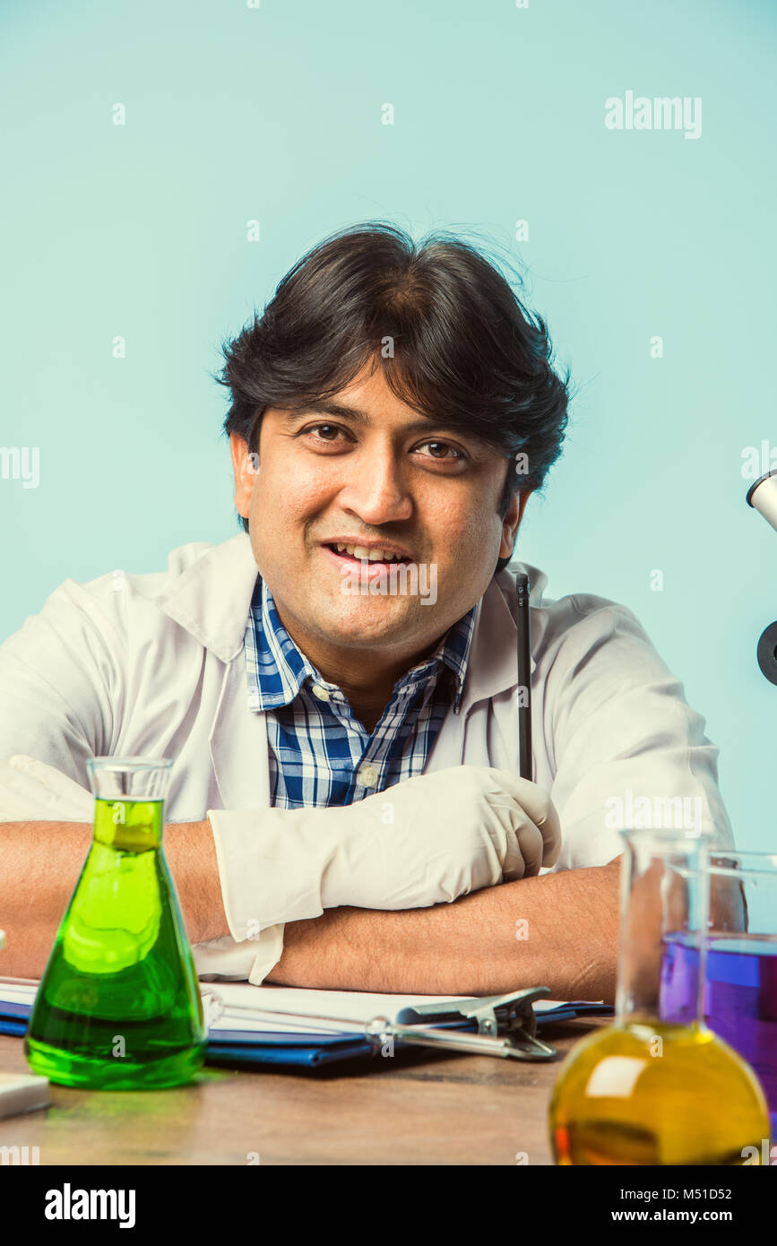 Asian/Indian male scientist or doctor or science student experimenting ...