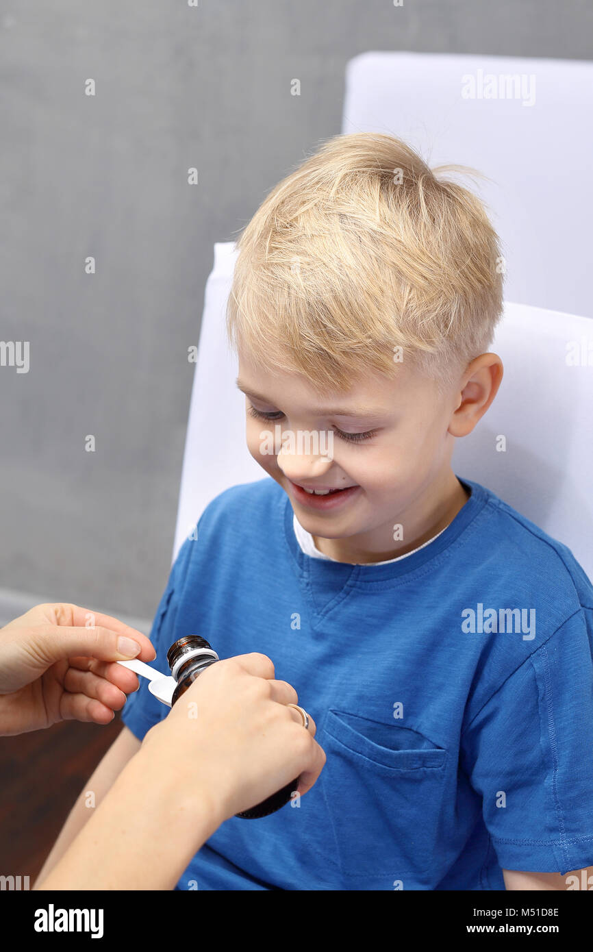 The child takes the medicine in syrup. Mom gives the child medicine in ...