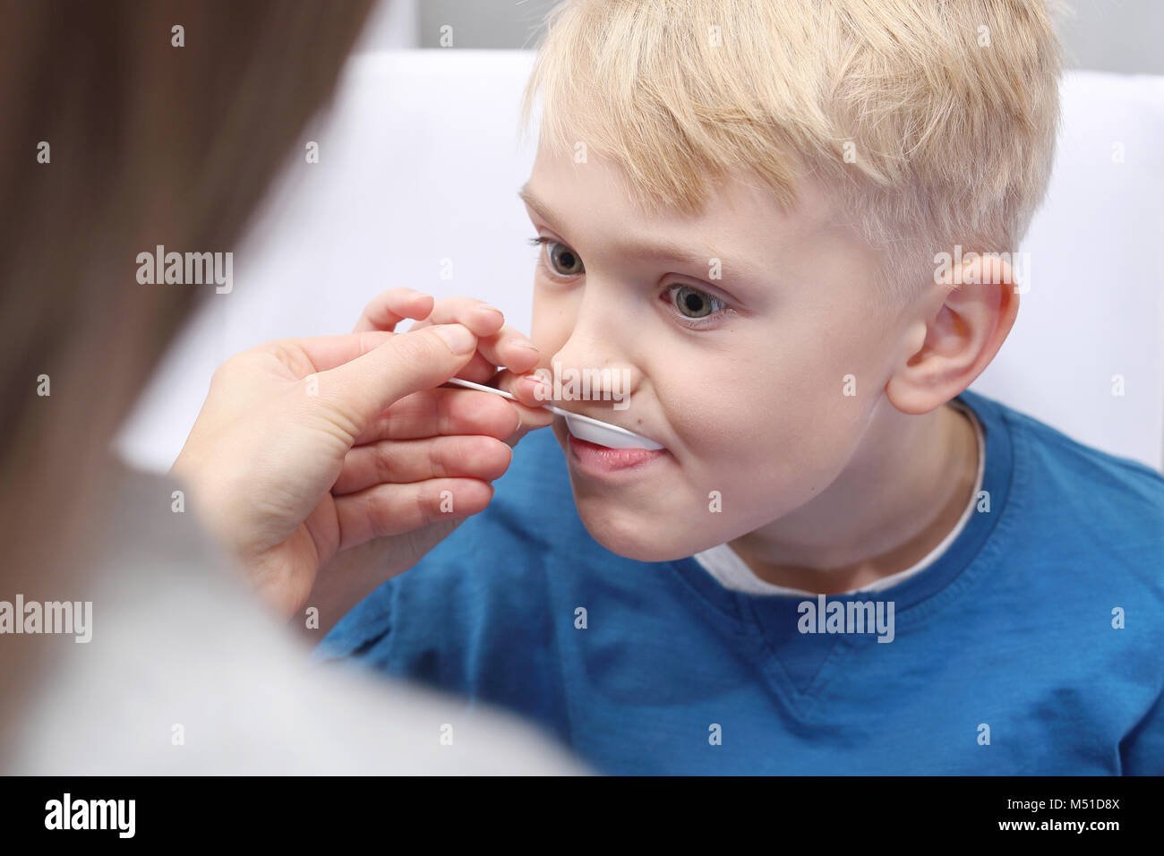 Cold syrup. The child takes the medicine in syrup Stock Photo - Alamy