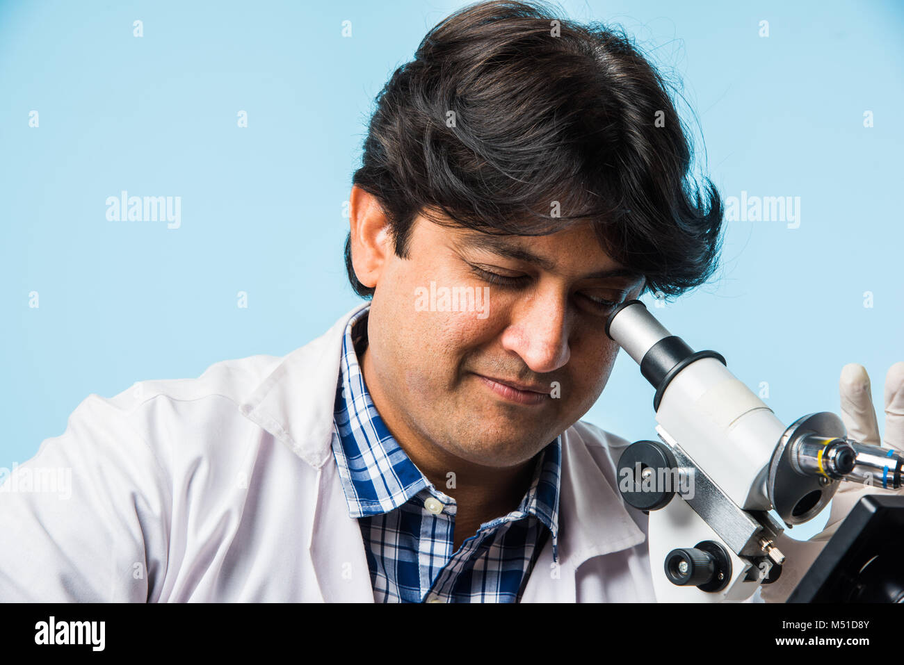 Asian/Indian male scientist or doctor or science student experimenting ...