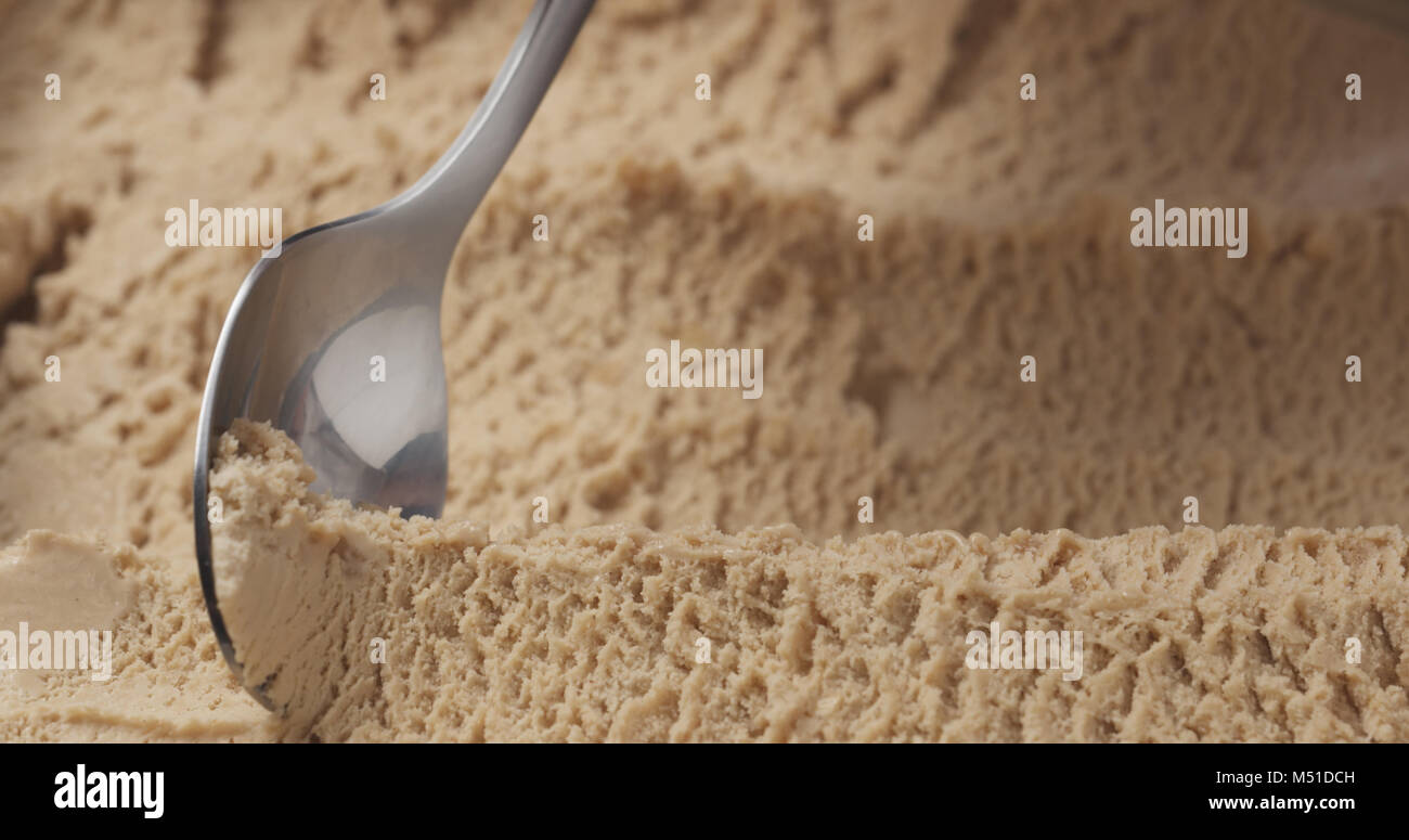 closeup hazelnut praline ice cream scooping with spoon, wide photo ...
