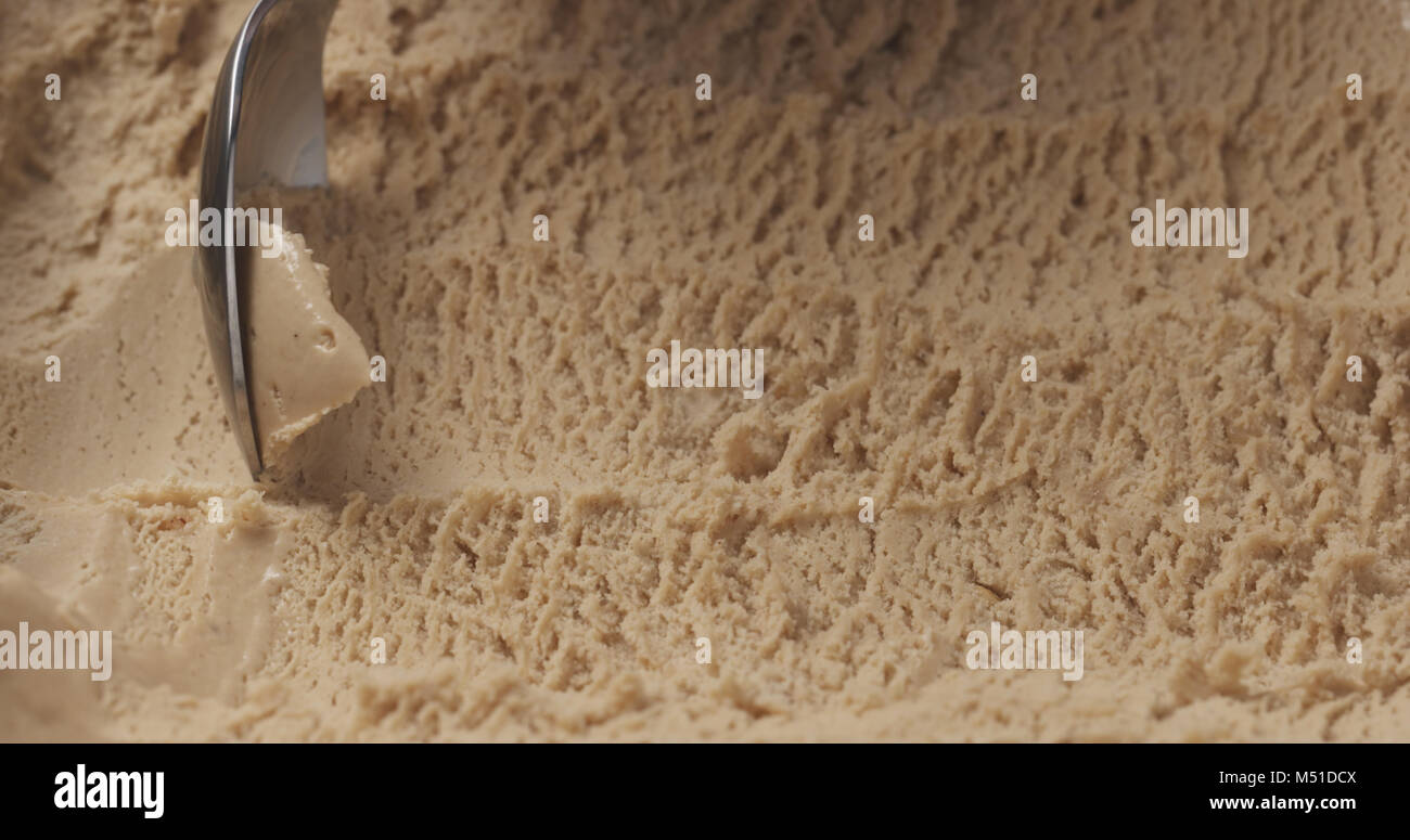 closeup hazelnut praline ice cream scooping with spoon, wide photo ...