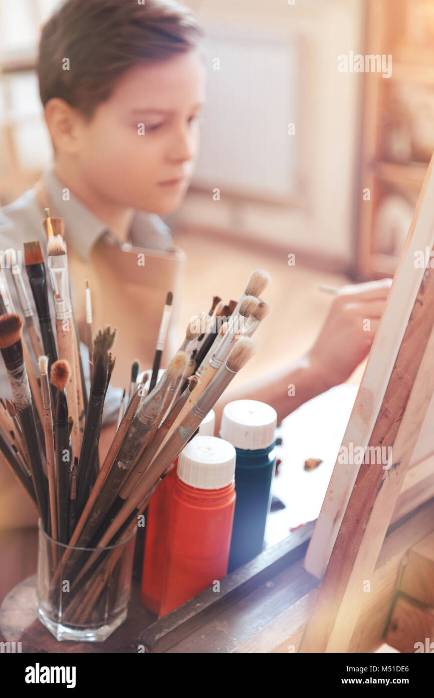 Serious teen boy painting masterpiece in studio Stock Photo - Alamy