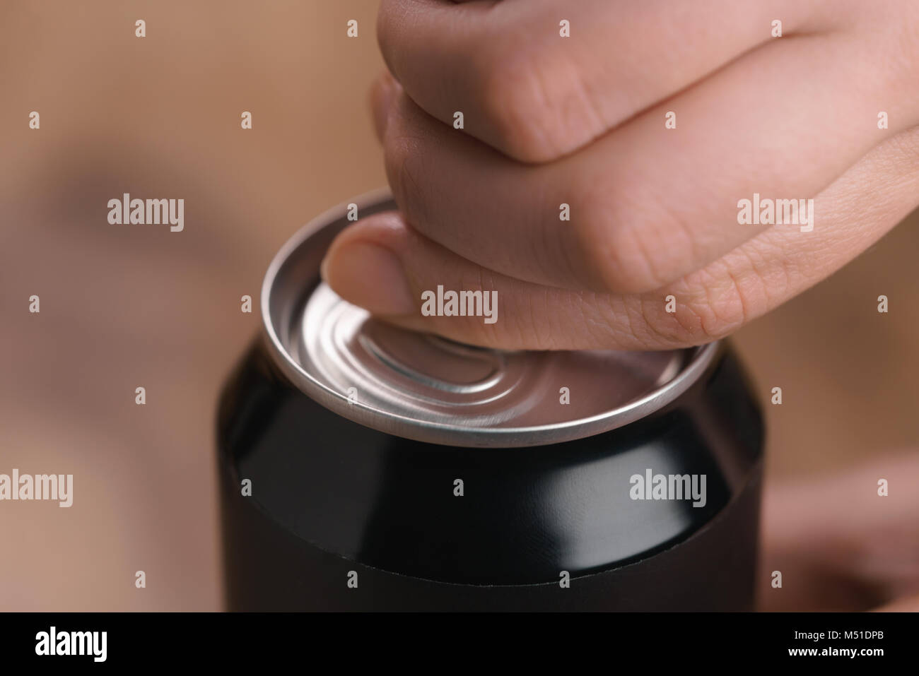 closeup young female hand opening black can with beverage, shallow ...