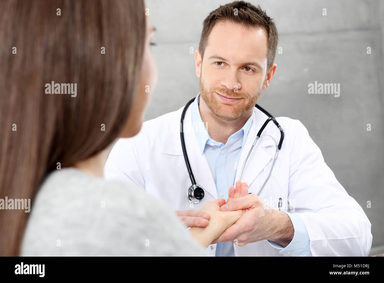 Medical examination. The doctor examines the patient's heart rate by ...