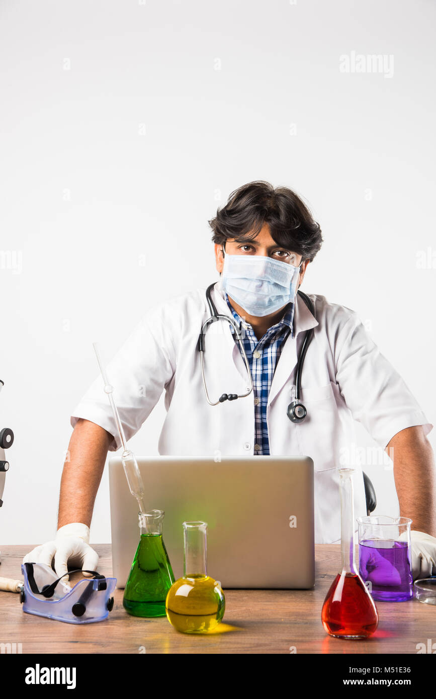 Asian/Indian male scientist or doctor or science student experimenting ...