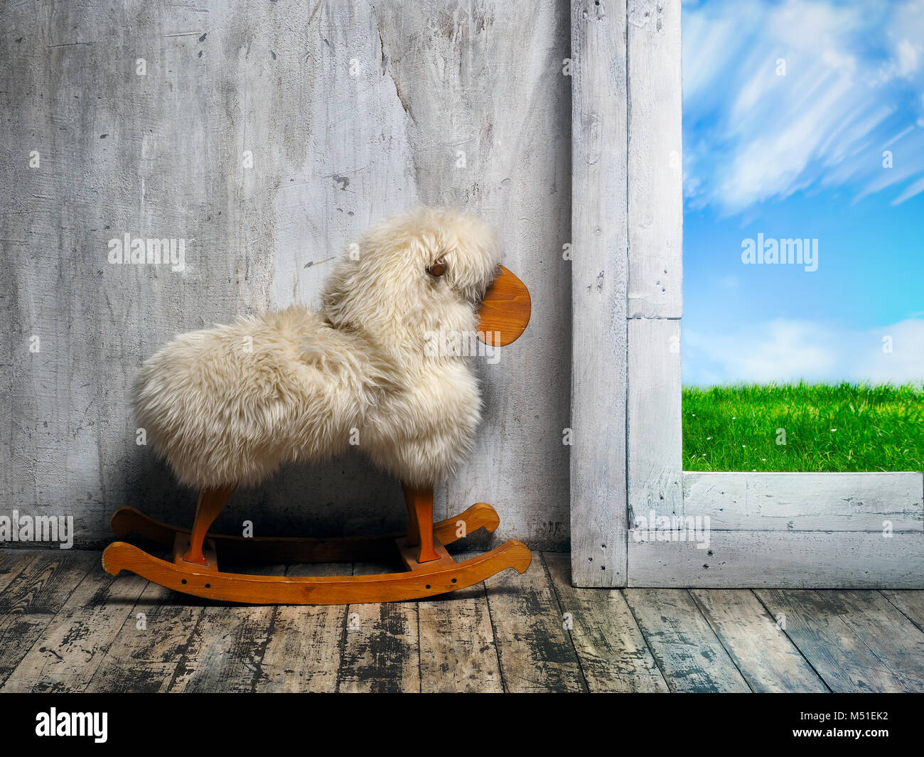 Children's rocking chair in the form of sheep. Old concrete wall. The ...