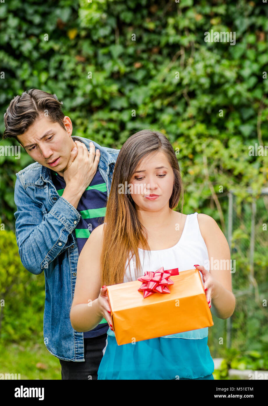 Close up of young woman doing a face of detesting the gift she is ...