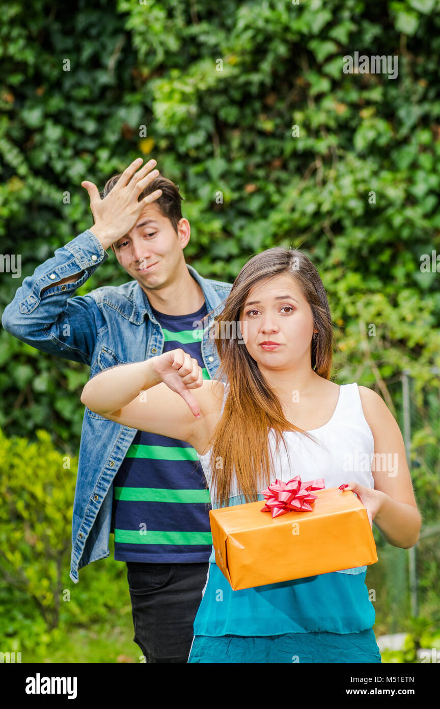 Close up of young woman doing a face of detesting the gift she is ...