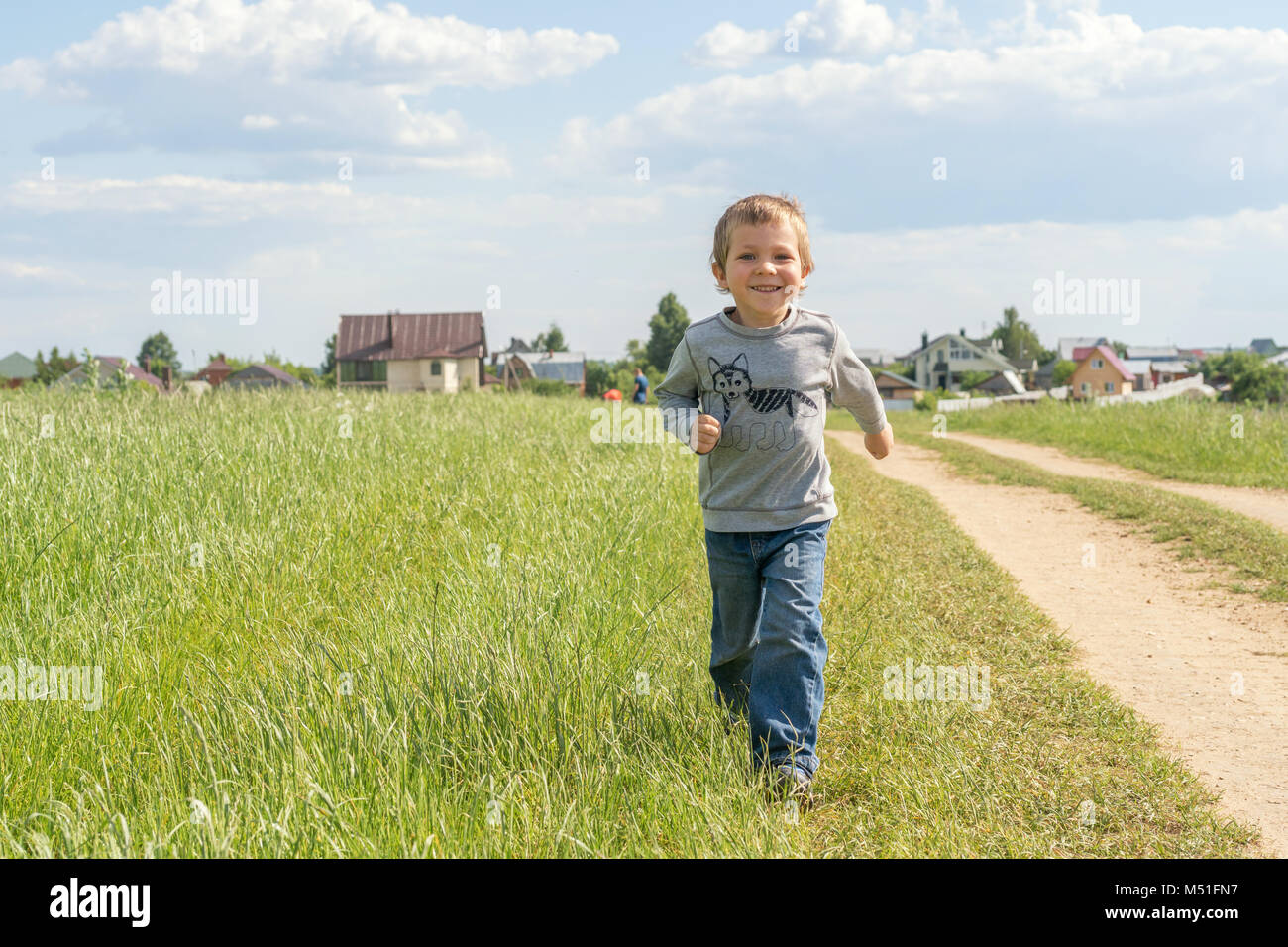 Happy boy running on the field Stock Photo - Alamy