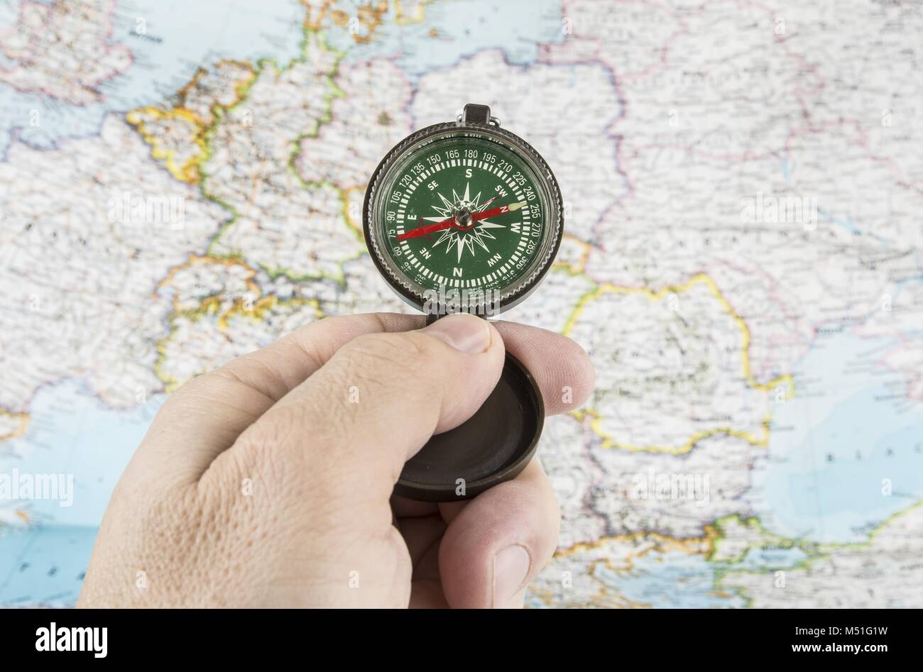 Compass in the hand with map in the background Stock Photo - Alamy