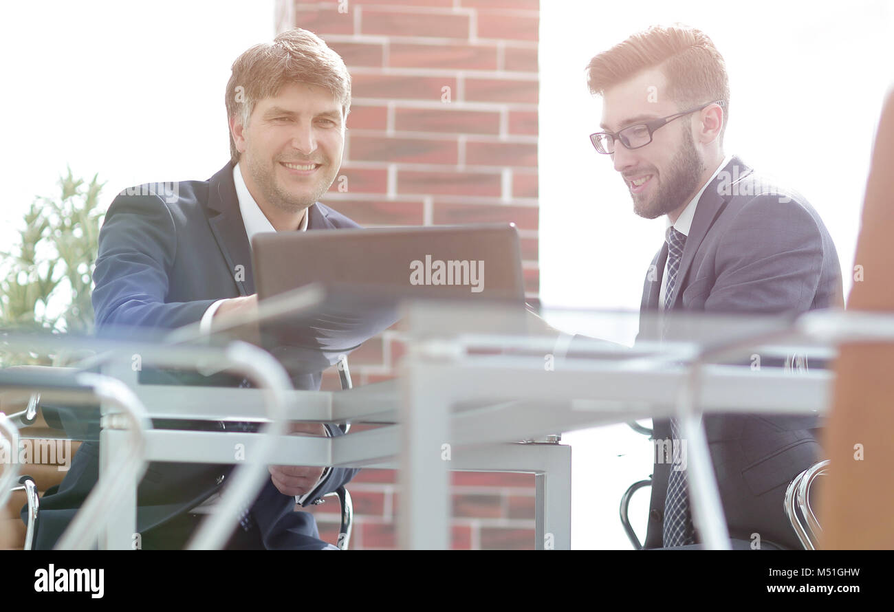 Two businessmen working together using laptop on business meetin Stock ...