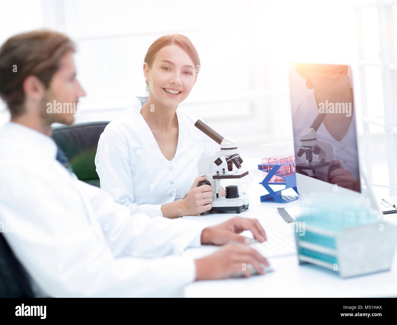 Lab expert working on a test using microscope Stock Photo - Alamy
