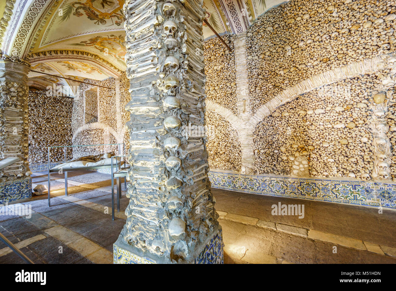 Close-up of a bone-laid pillar with a skeleton in a glass case in the ...