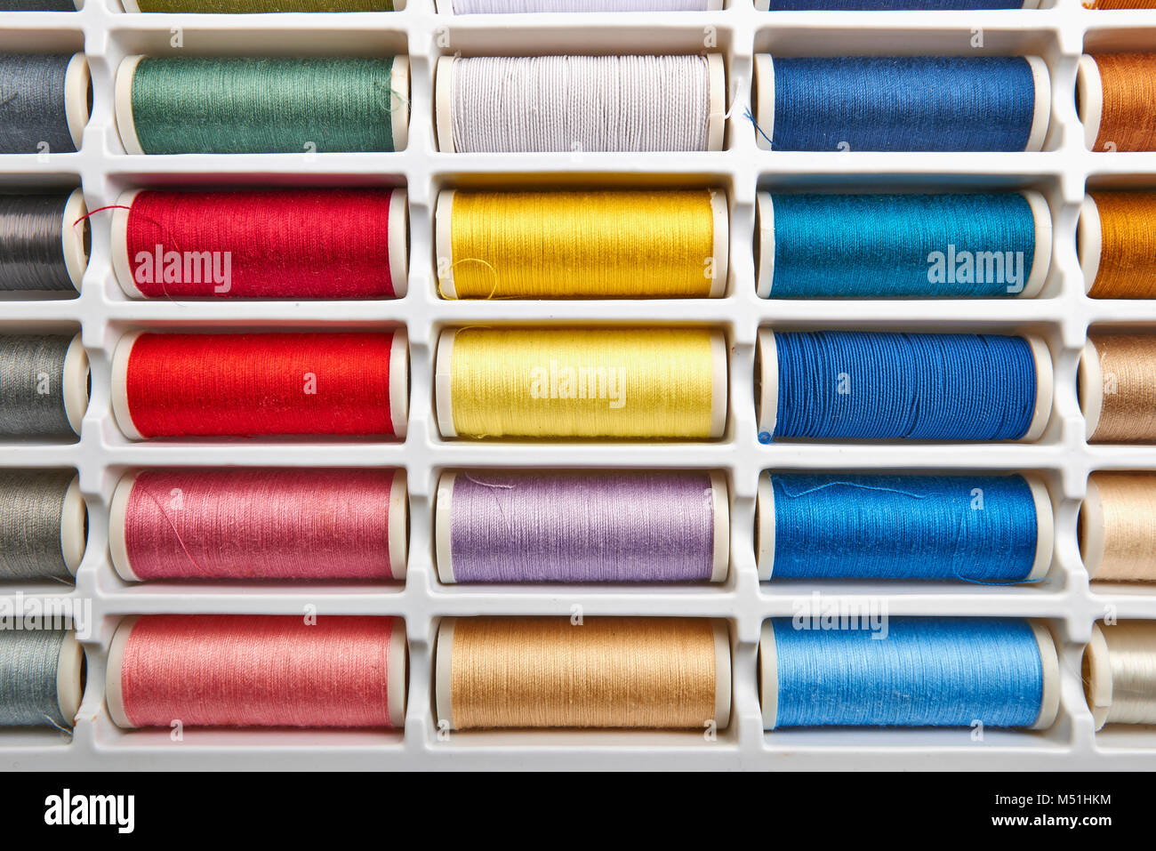 Sewing threads multicolored background closeup Stock Photo - Alamy