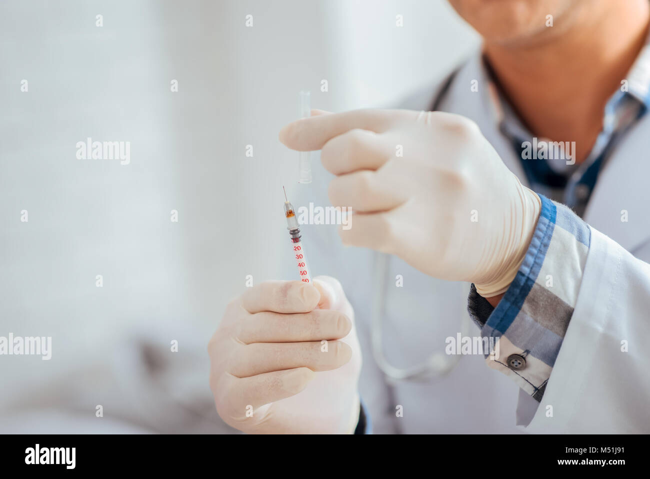 Close up of doctor checking syringe Stock Photo - Alamy