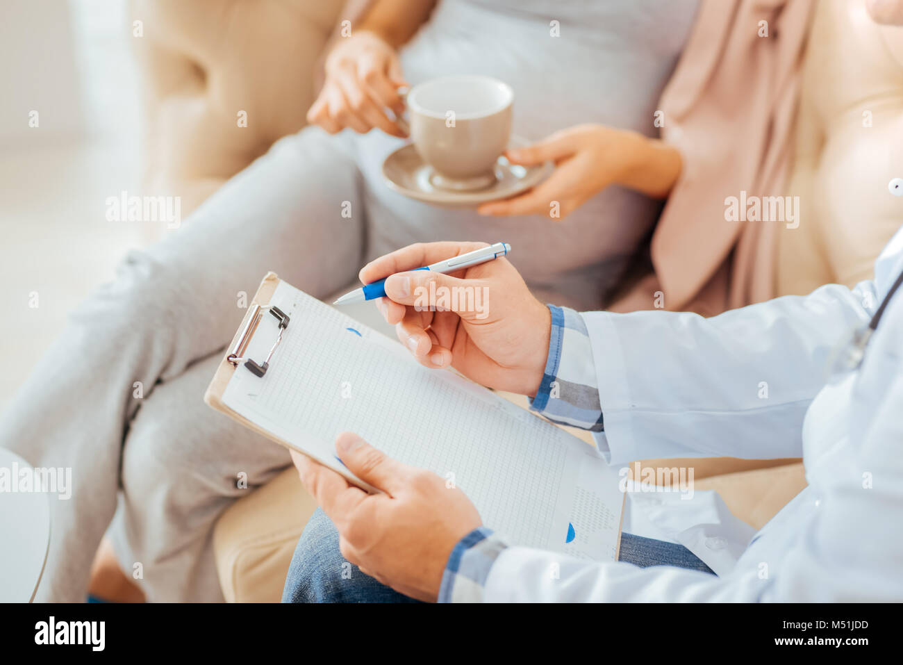 Close up of doctor taking notes during appointment Stock Photo - Alamy