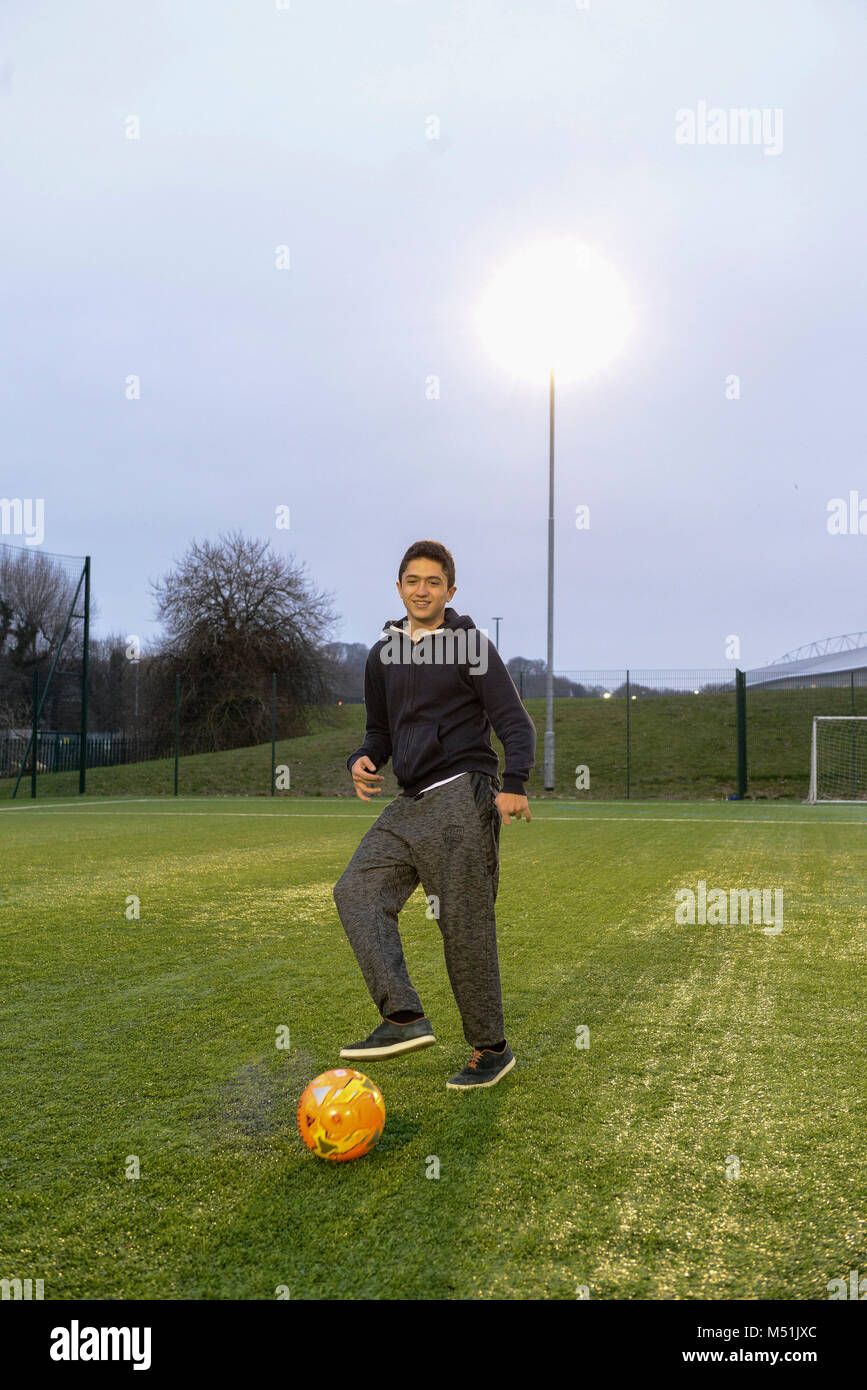 school students having a football lesson to improve their skills at ...