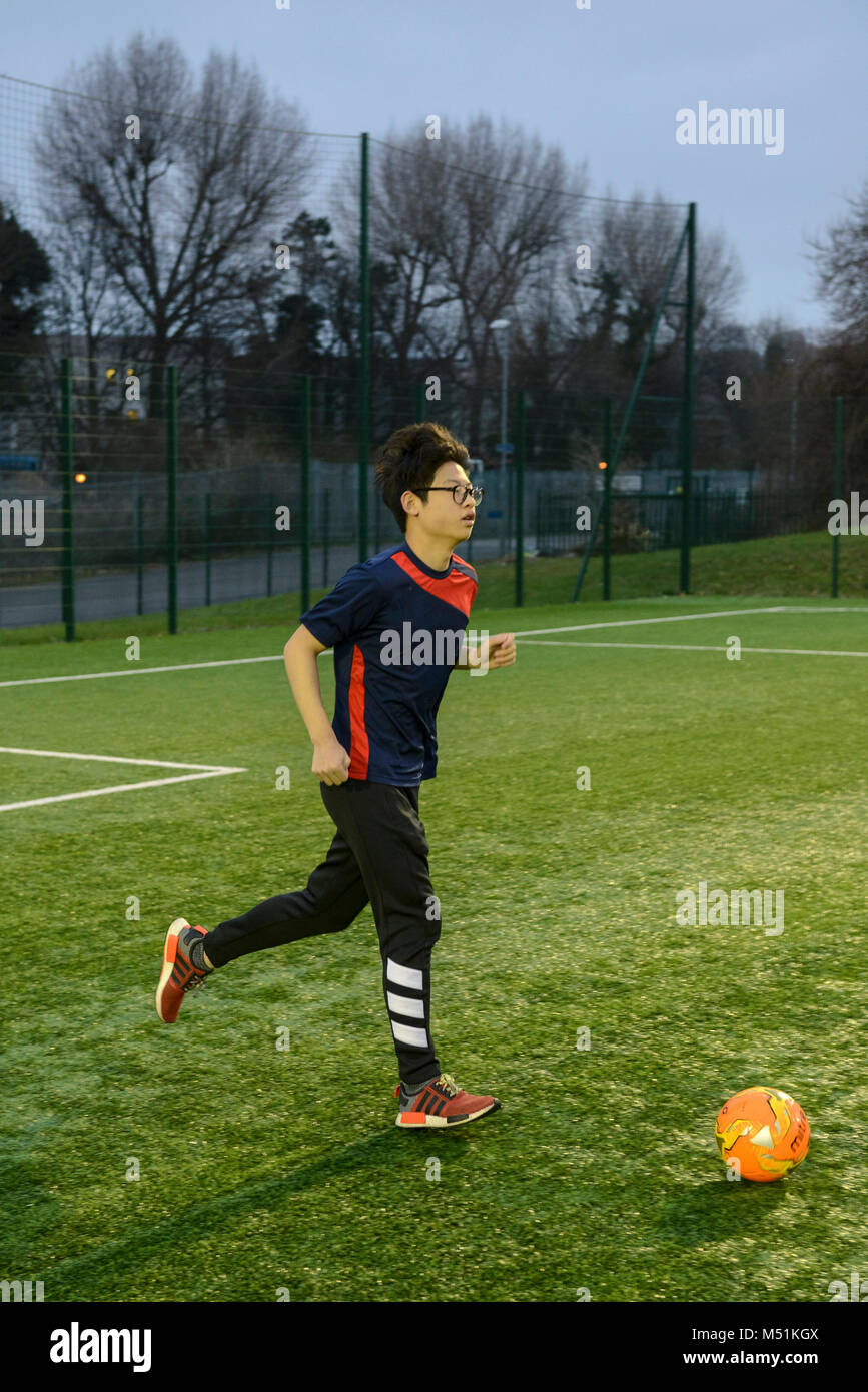 school students having a football lesson to improve their skills at ...