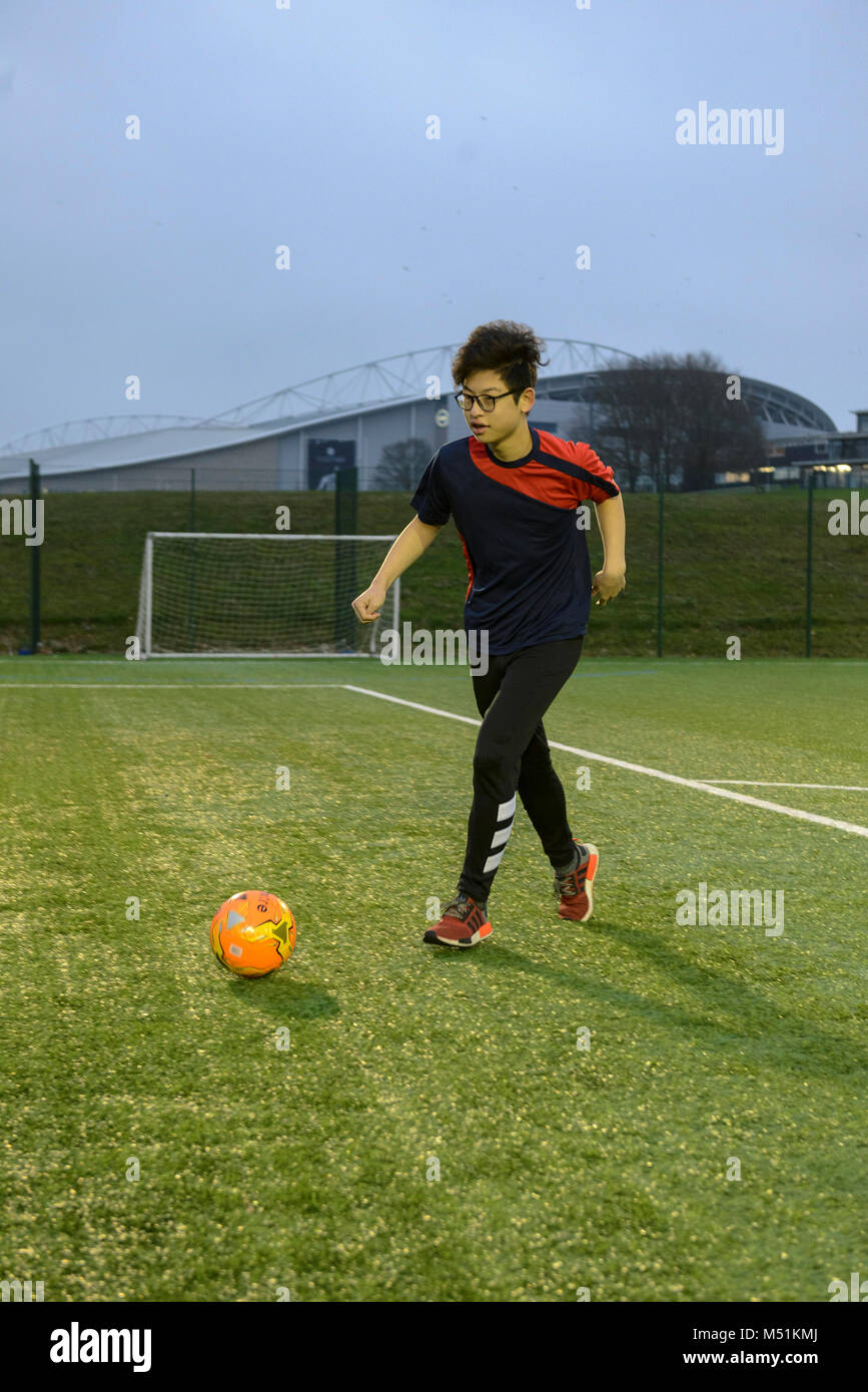 school students having a football lesson to improve their skills at ...