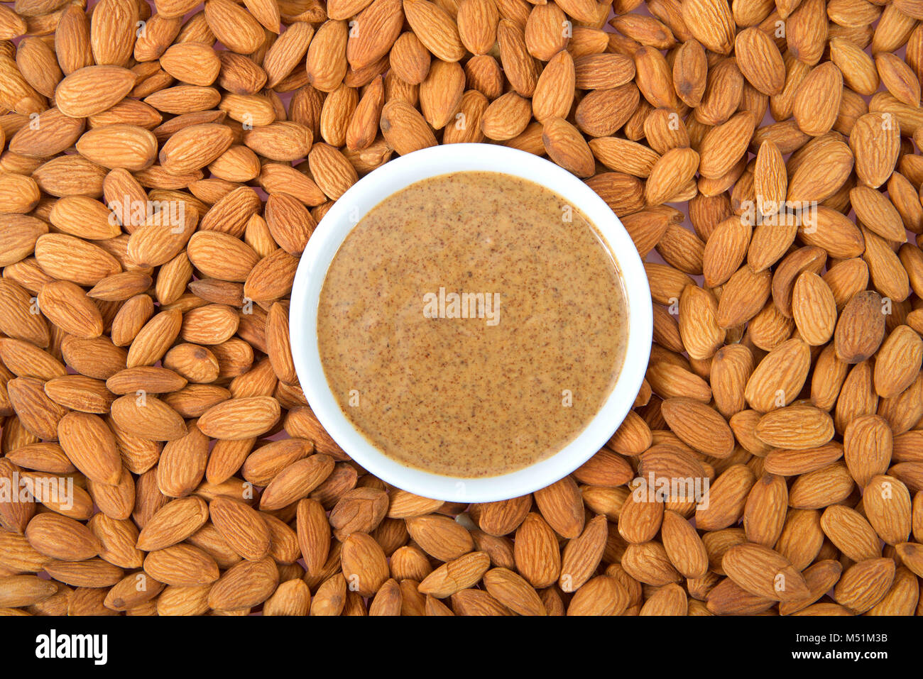 White bowl with fresh almond butter surrounded by almonod nuts. Almonds ...