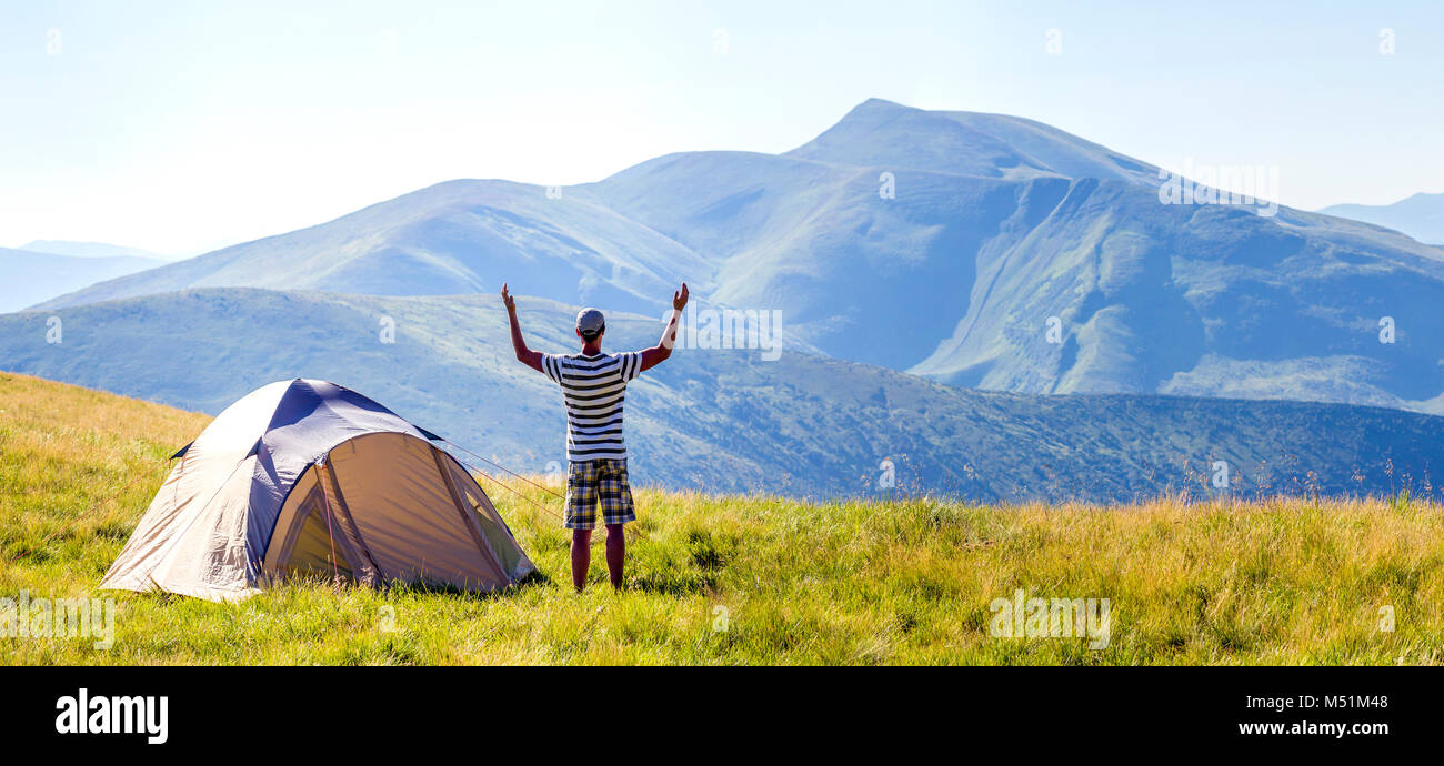 Panoramic view of hiker who meets good morning with raised hands just ...