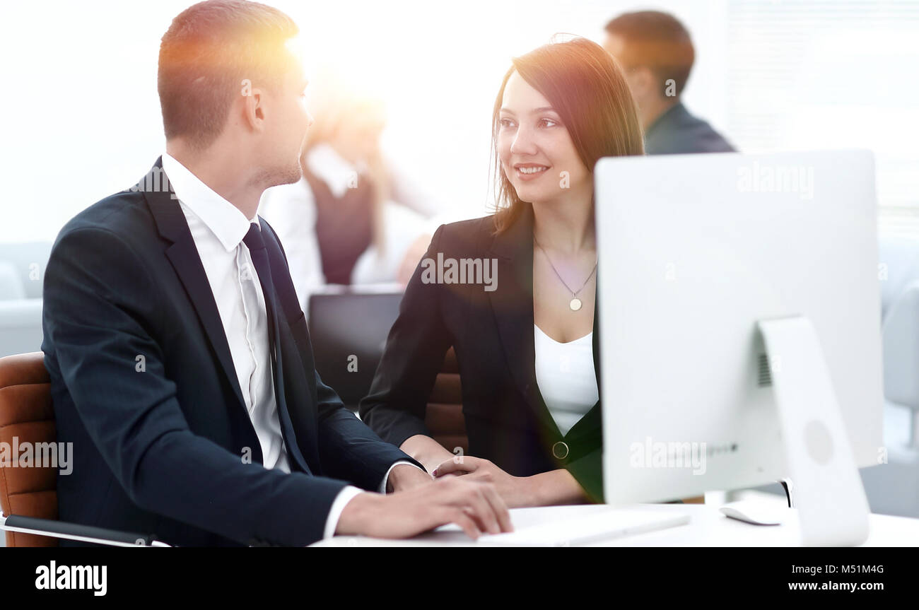 employees sitting behind a Desk in the office Stock Photo - Alamy