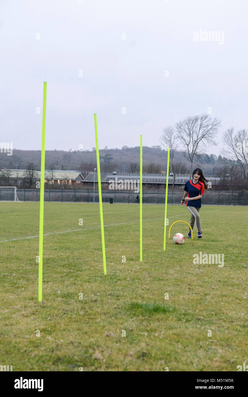 school students having a football lesson to improve their skills at ...