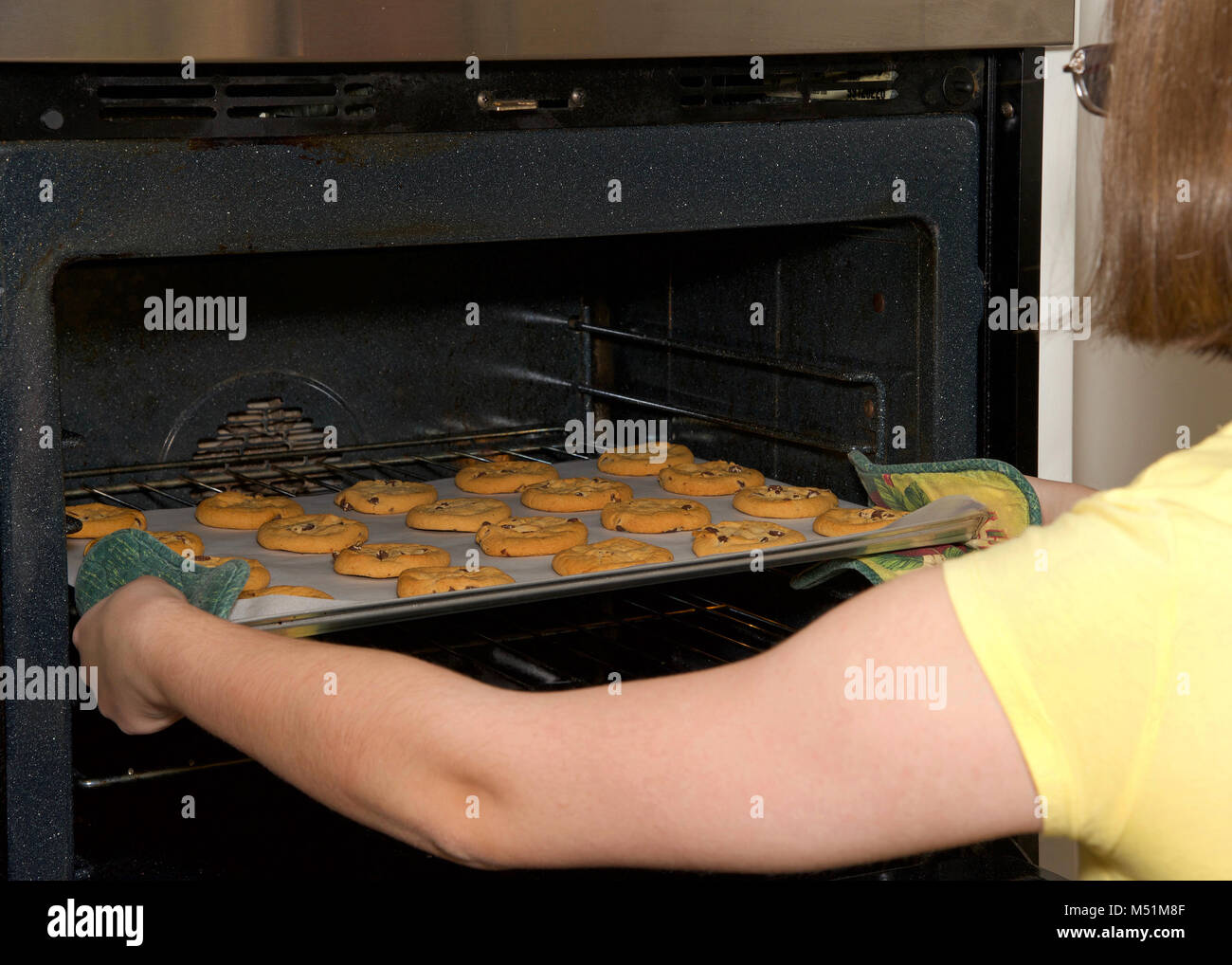 Close up on young female hands pulling tray of soft and chewy chocolate ...