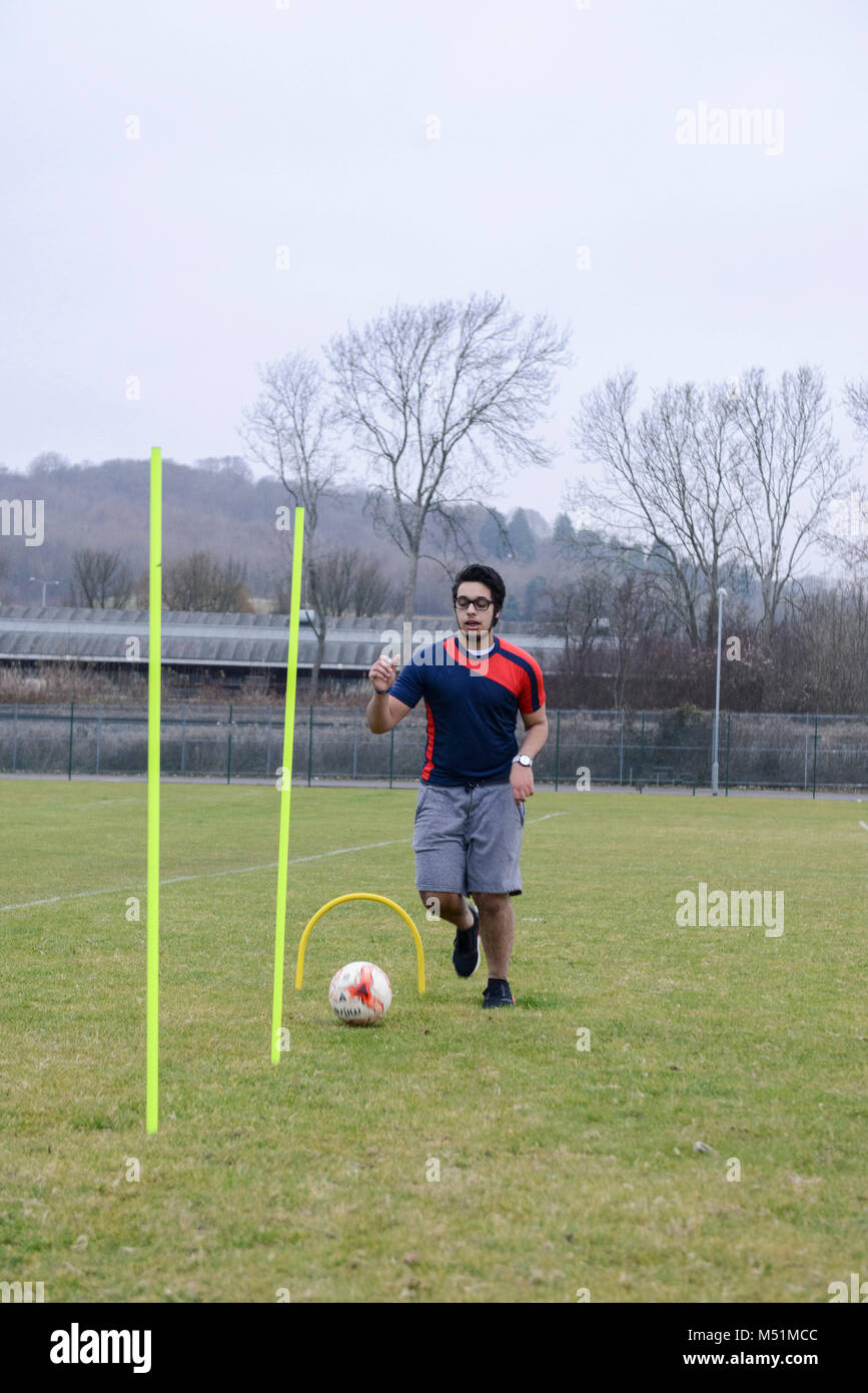 school students having a football lesson to improve their skills at ...